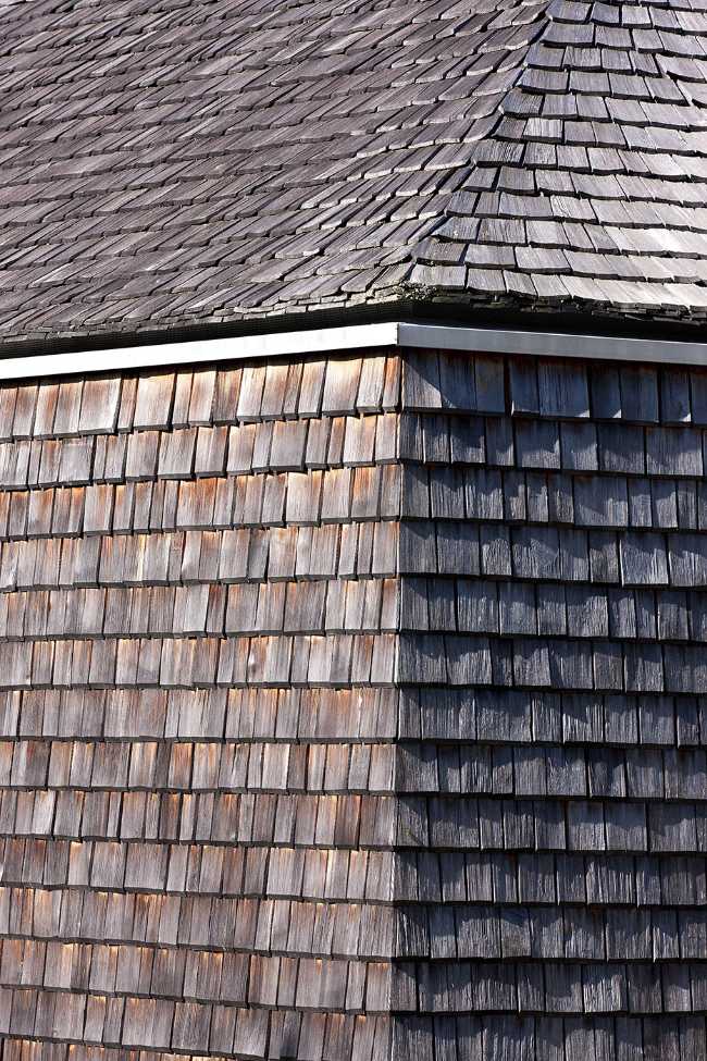 Mountain house built on a slope. Local wooden tile cladding